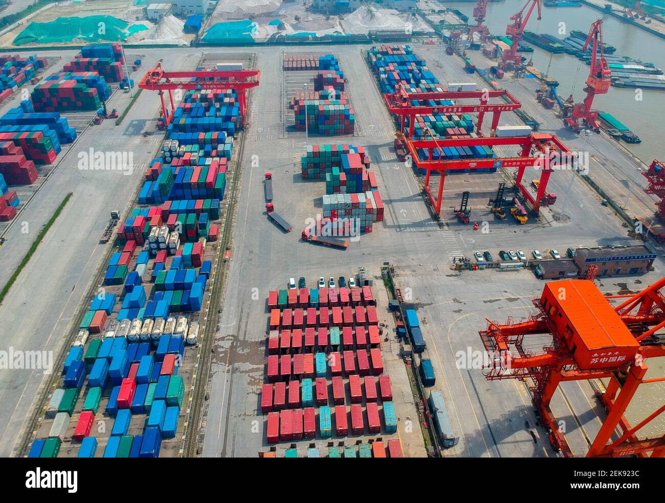 An aerial of cranes standing and containers arrayed at the Rugao port ...