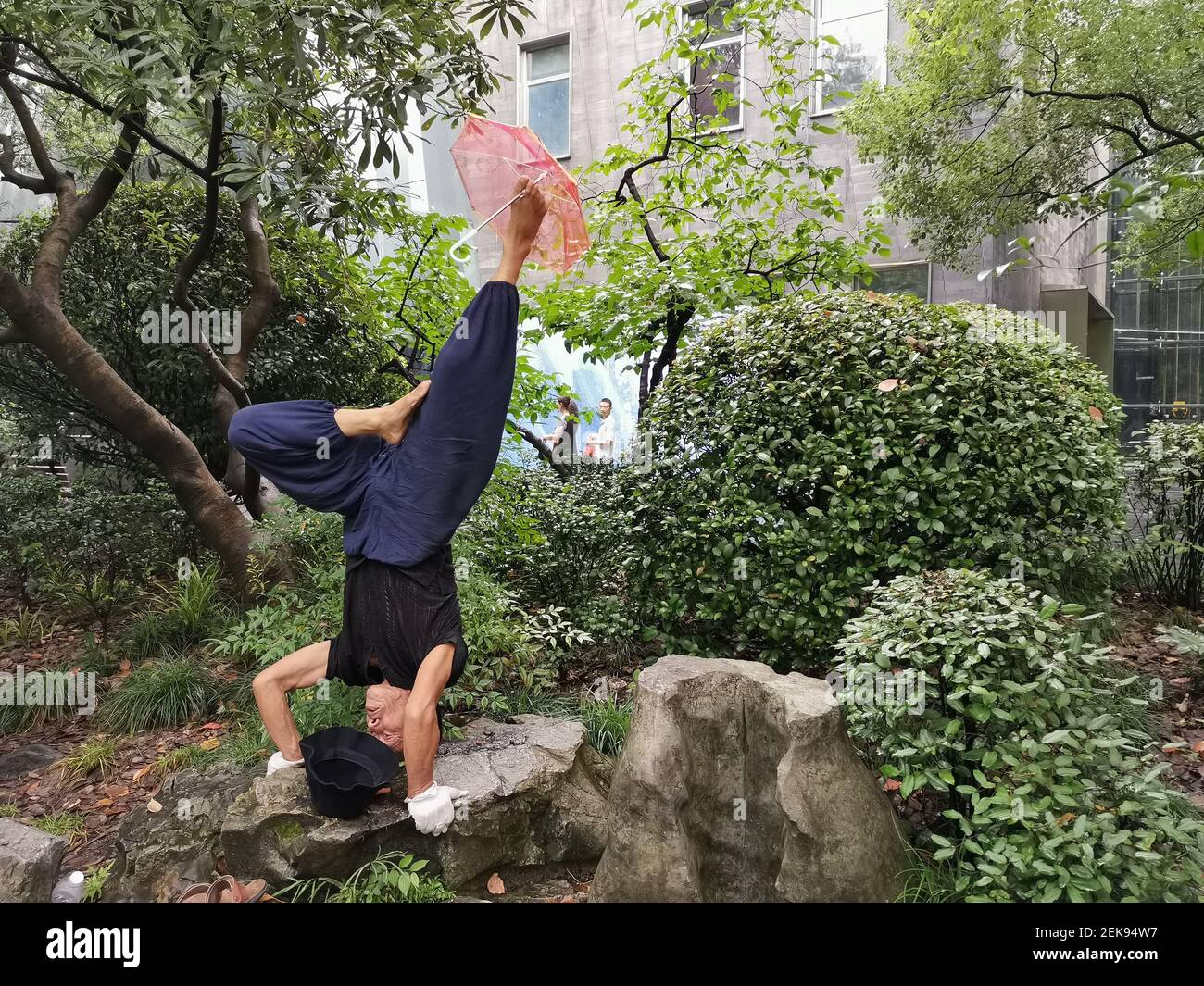 Mr. Jiang, a man in his seventies, practices Yoga in a special way, standing upside down with ...
