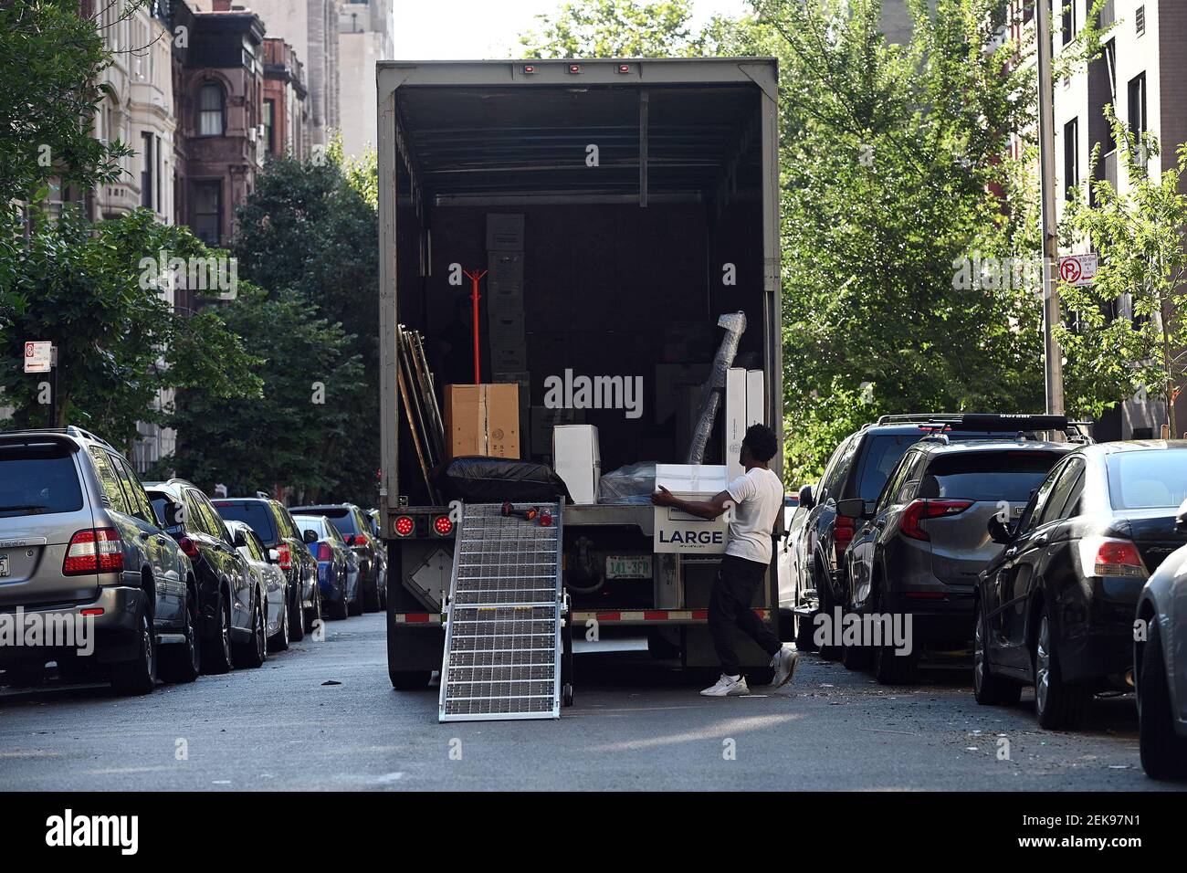 Mover Paul Cline helps load moving truck with the final belongings of a ...