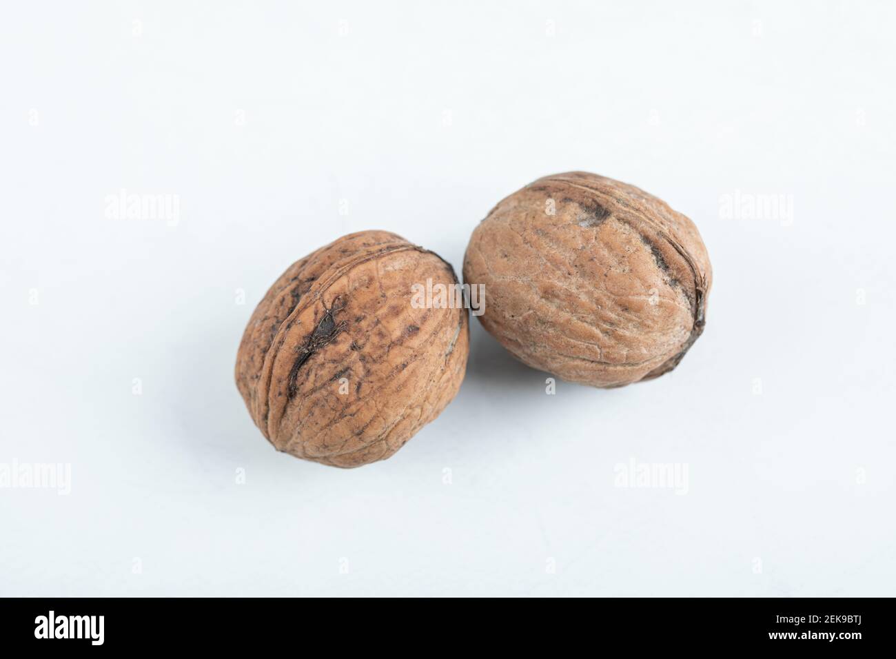 Two whole healthy walnuts on a white background Stock Photo - Alamy