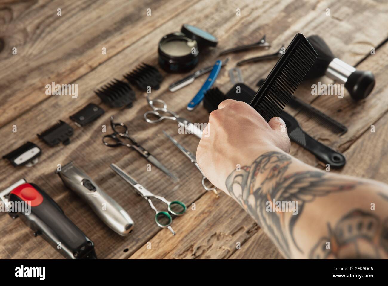 Hand of barber with equipment set on wooden table background. Close up ...