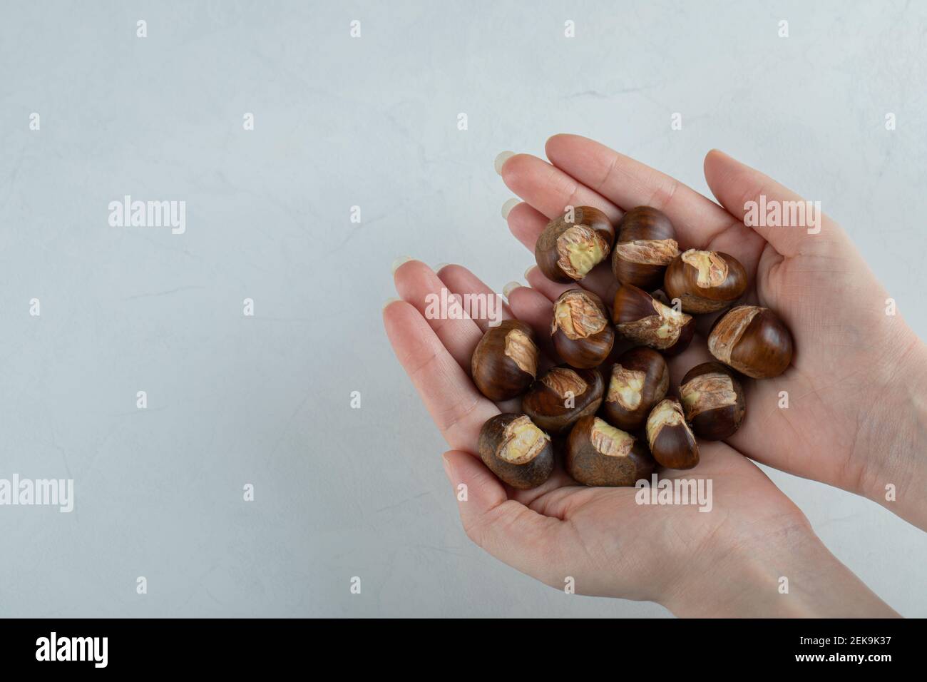 Hands holding many of healthy chestnuts on a white background Stock ...