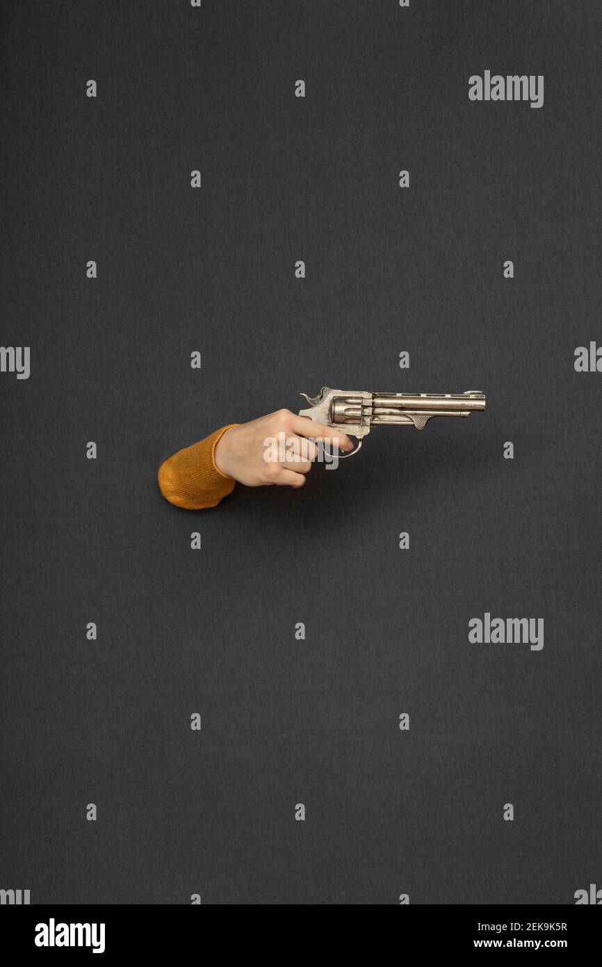 Studio shot of female hand holding old-fashioned revolver Stock Photo ...