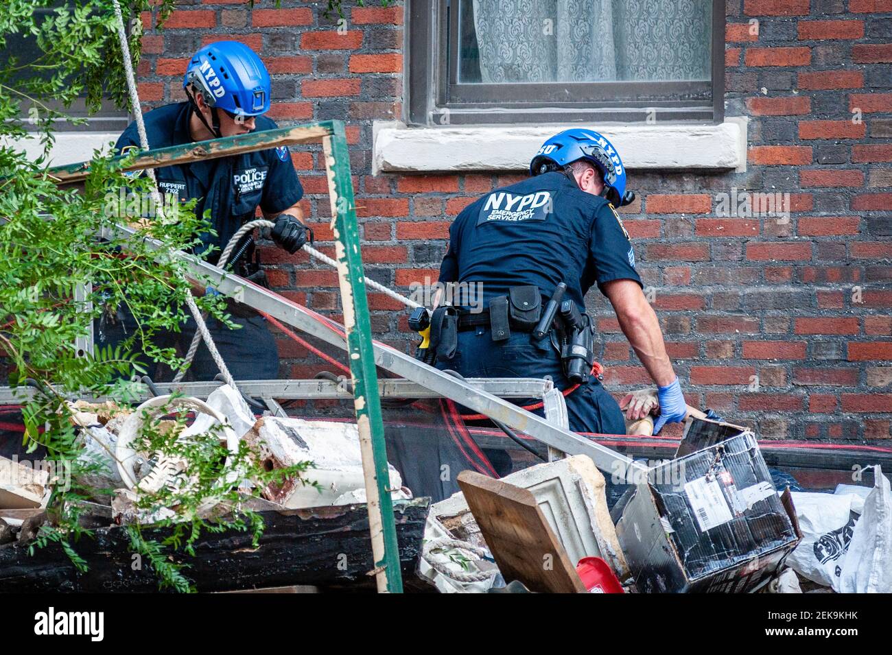 Two NYPD police officers carefully wrap the body of the construction ...