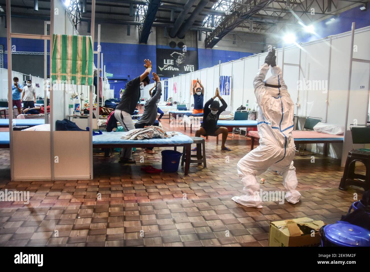 A health worker wearing a Personal Protective Equipment (PPE) instructs ...