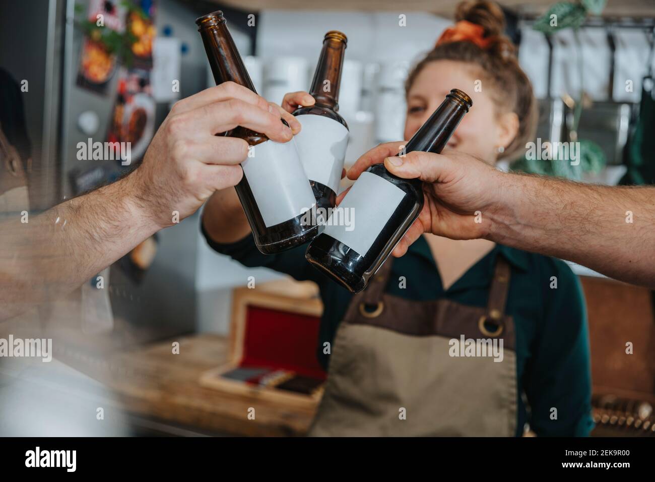 Chefs toasting beer bottles while standing in kitchen Stock Photo - Alamy