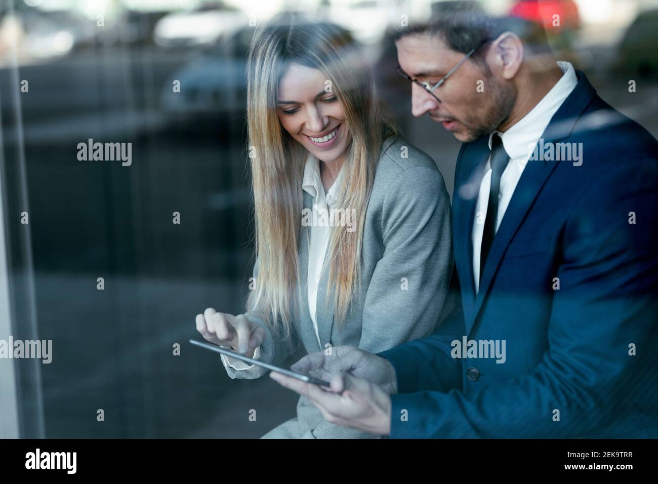 Businessman having discussion over digital tablet with colleague while ...