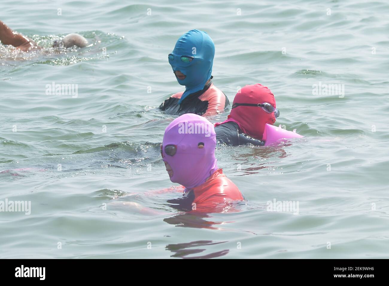 People enjoy beach and sunshine with facekini on, a mask designed for ...