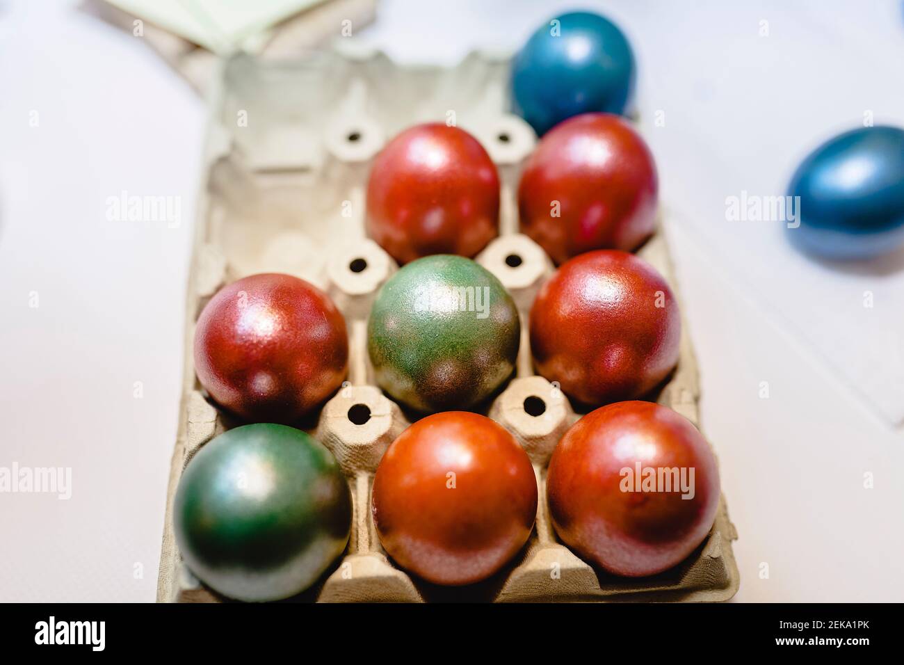 Multi colored Easter eggs in tray on table at home Stock Photo - Alamy