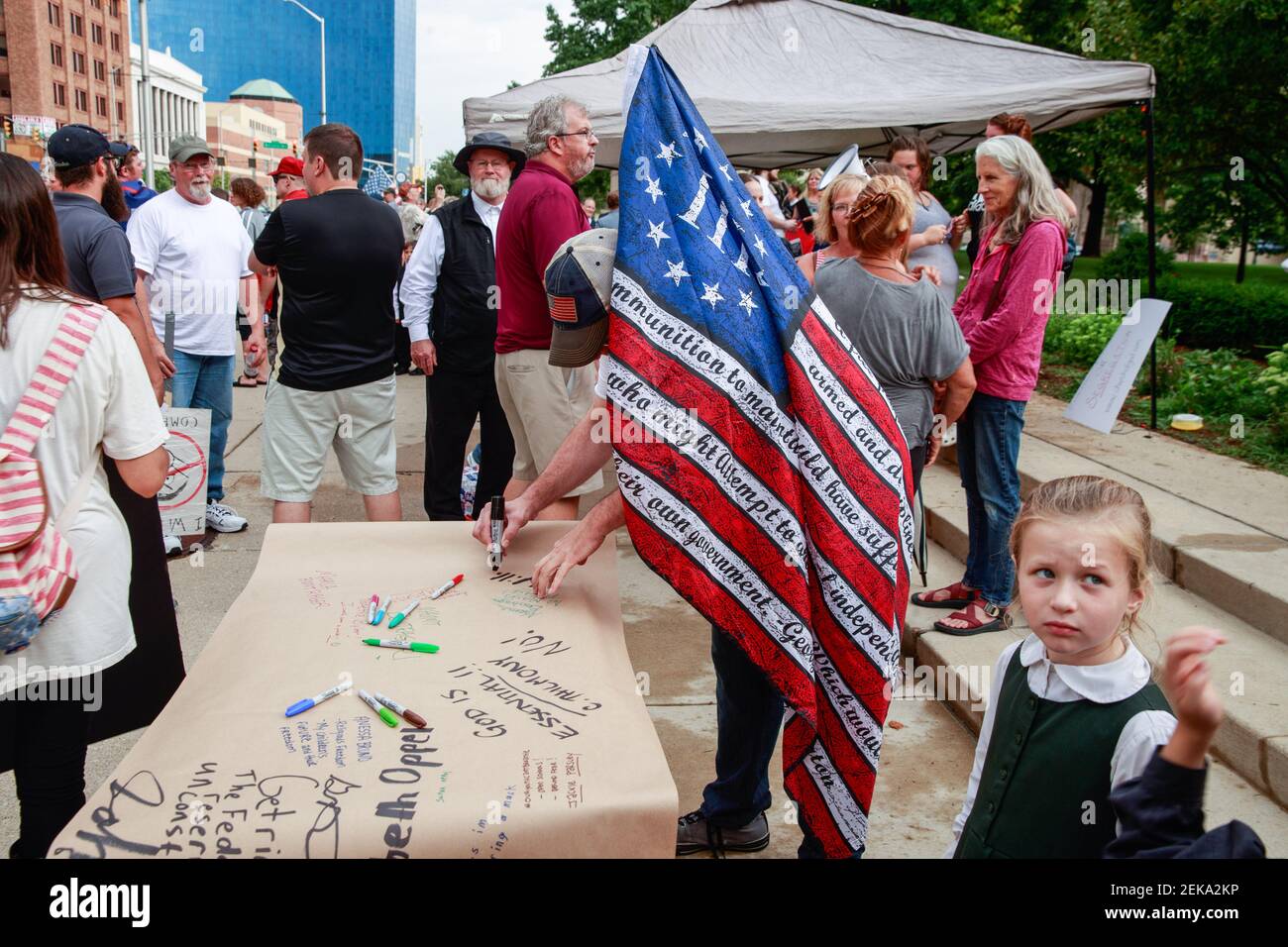 Protesters sign a banner to be left on the doors of the Statehouse ...
