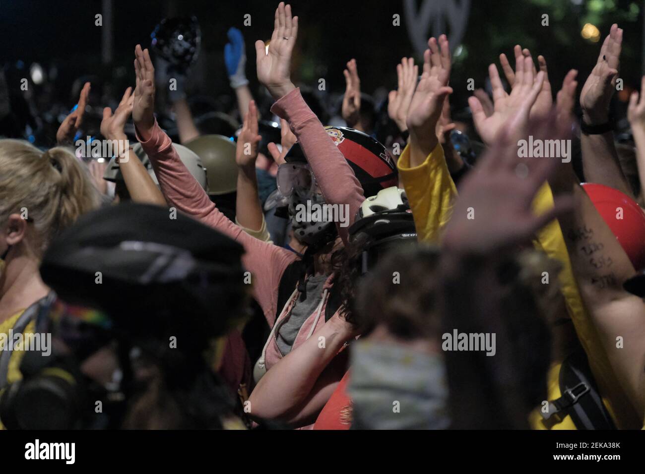 Protesters hold their hands in the air as moms with interlocking arms ...