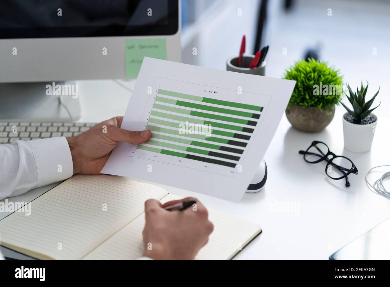 Businessman with graph paper document working on desk at work place ...