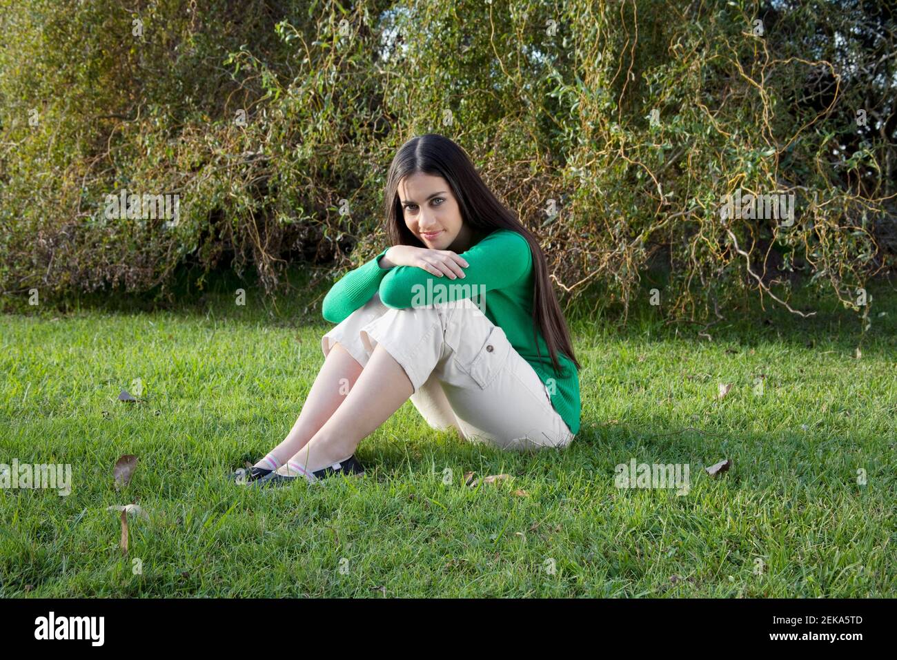 Portrait of a woman sitting on grass Stock Photo - Alamy