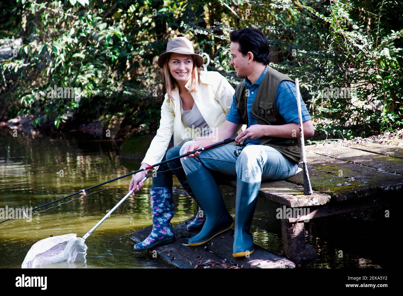 Couple fishing in a river Stock Photo - Alamy