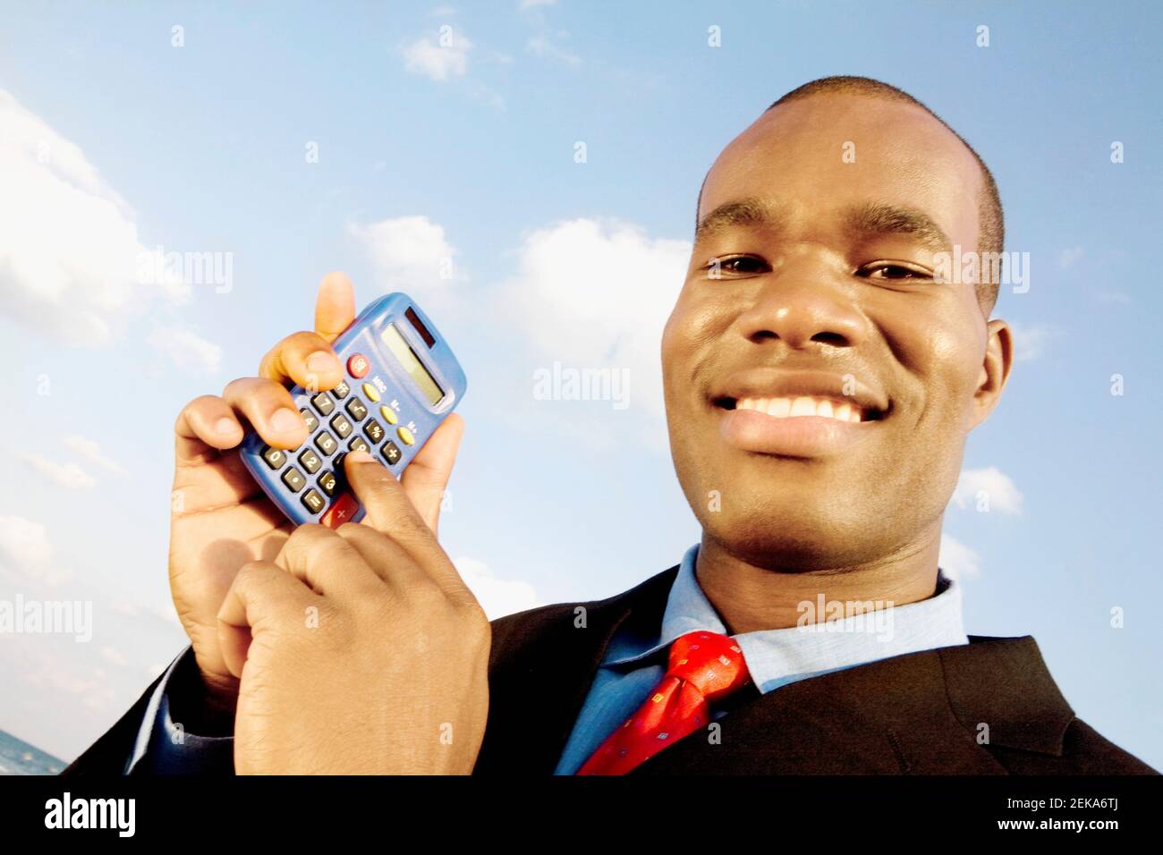 Portrait of a businessman holding a calculator and smiling Stock Photo ...