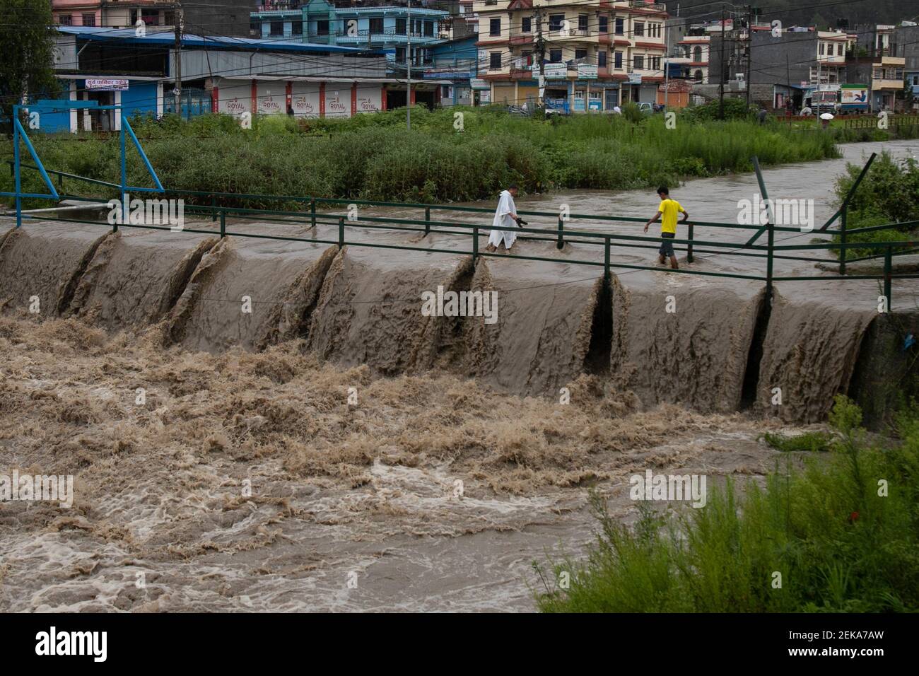 Nepalese peoples try to cross the bridge after heavy rains along the ...