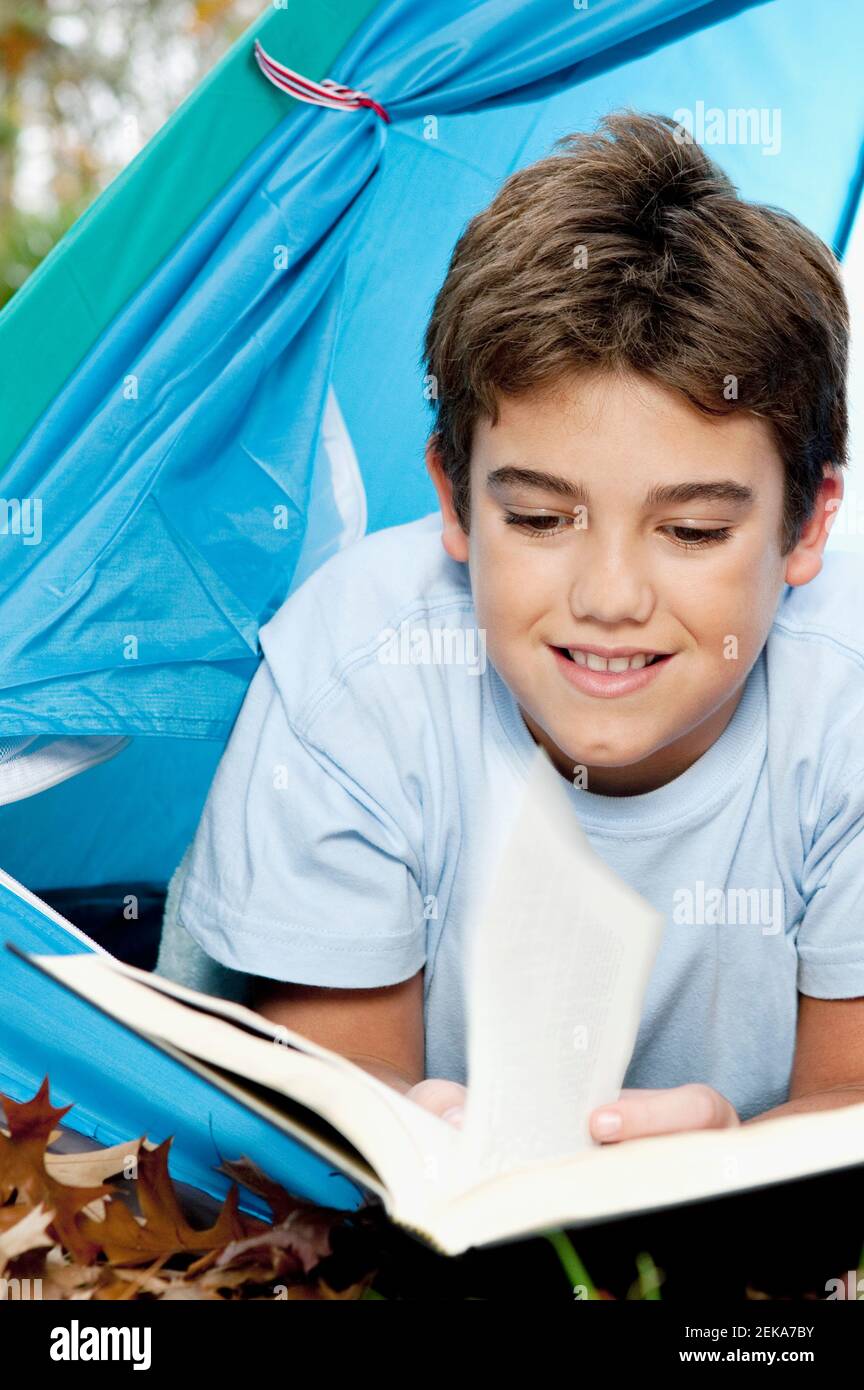 Boy reading a book in tent Stock Photo - Alamy