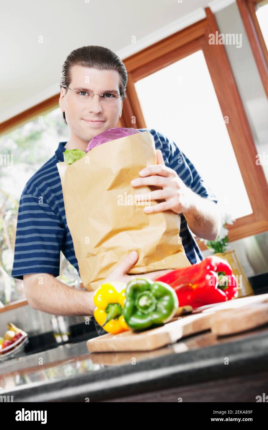 Man holding a paper bag of groceries Stock Photo - Alamy