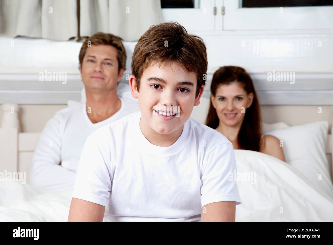 Portrait of a boy smiling with his parents in the background Stock ...