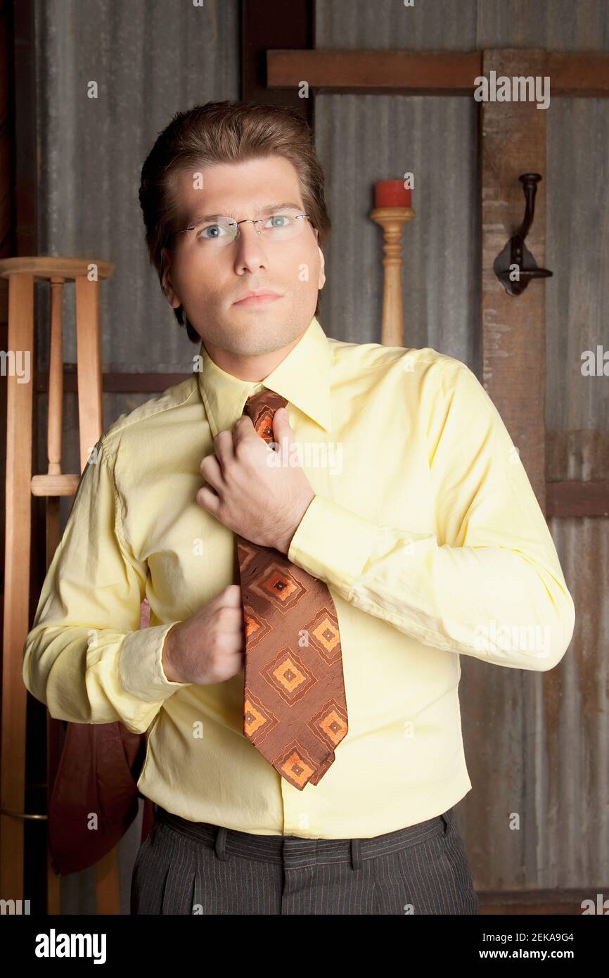 Portrait of a man adjusting his tie Stock Photo - Alamy