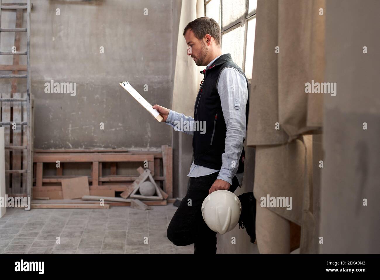 Male contractor analyzing document while standing in building Stock ...