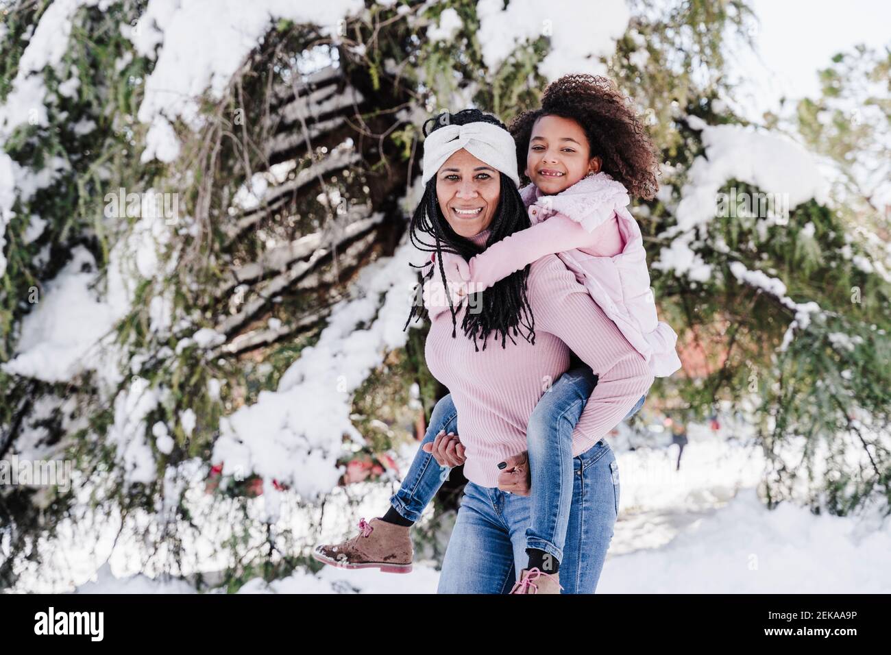 Happy mother giving piggyback ride to daughter in park Stock Photo - Alamy