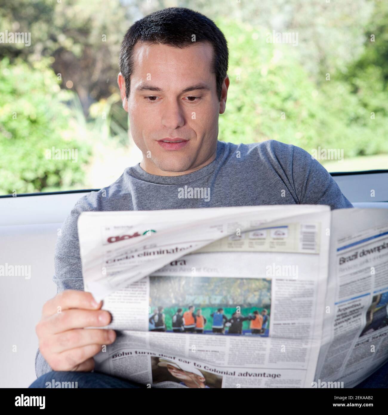 Man reading a newspaper in the park Stock Photo - Alamy