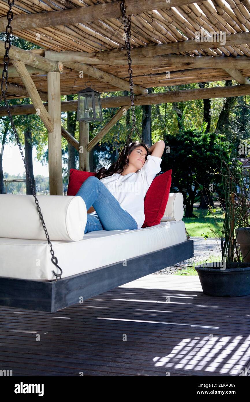 Woman napping on a porch swing Stock Photo - Alamy