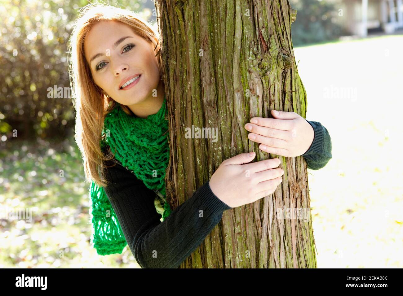 Portrait of a woman hugging tree Stock Photo - Alamy