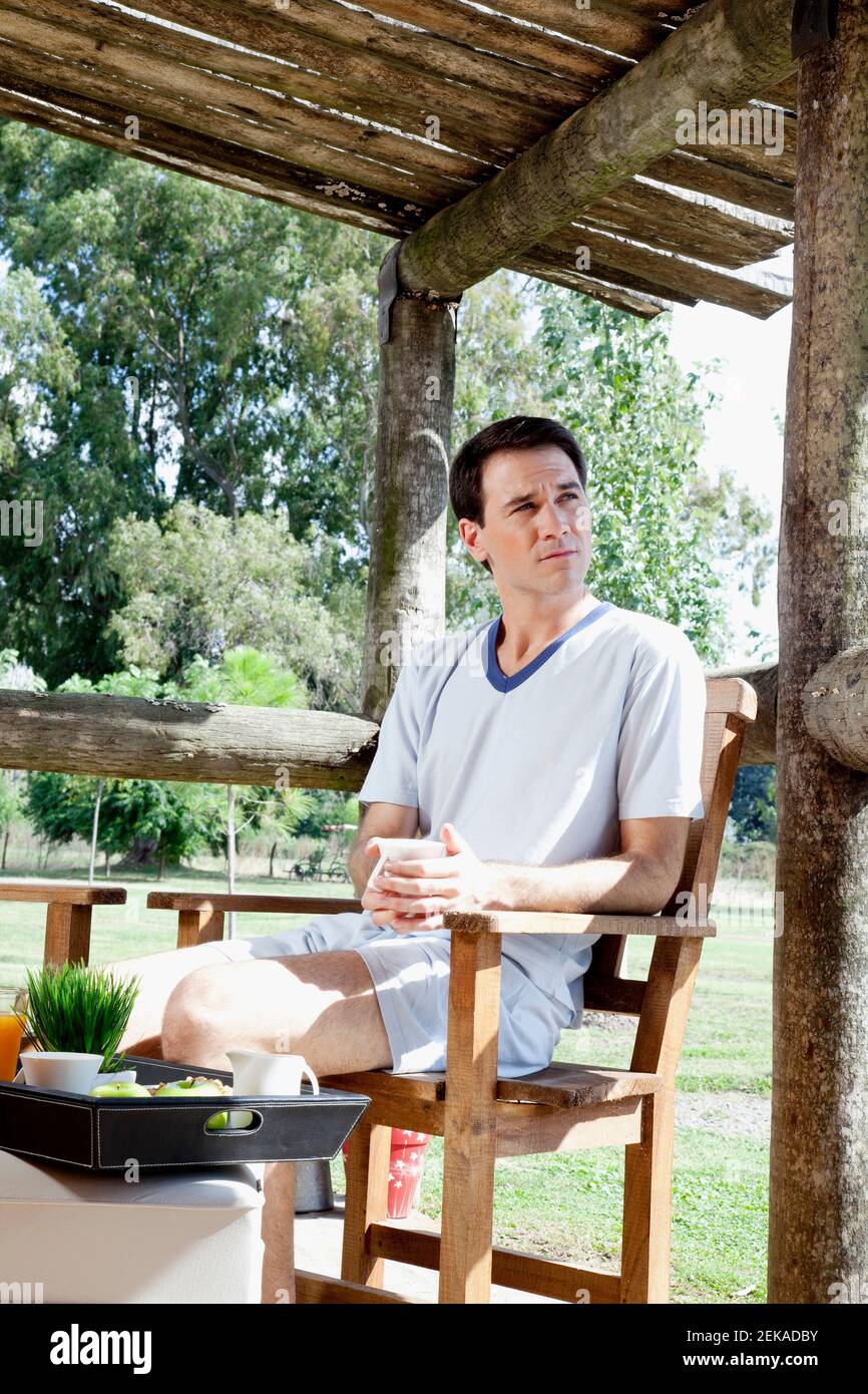 Man sitting on a chair and drinking tea Stock Photo - Alamy
