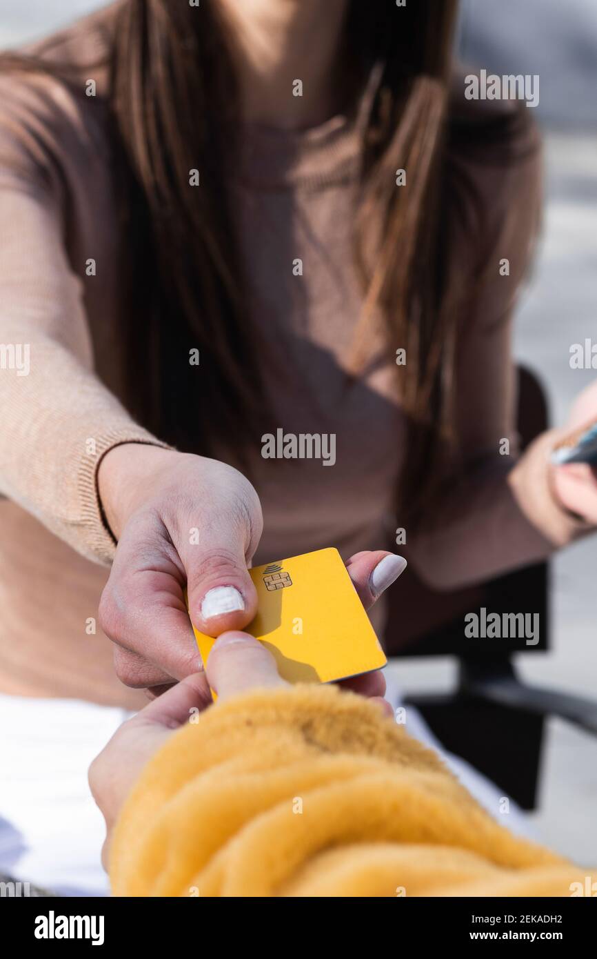 Person giving credit card to woman Stock Photo - Alamy