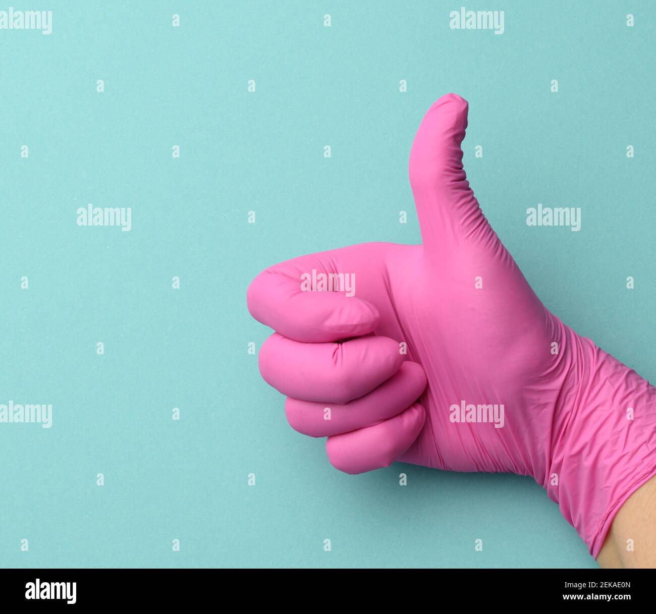 hand in pink medical glove shows right-handed gesture like on a blue ...