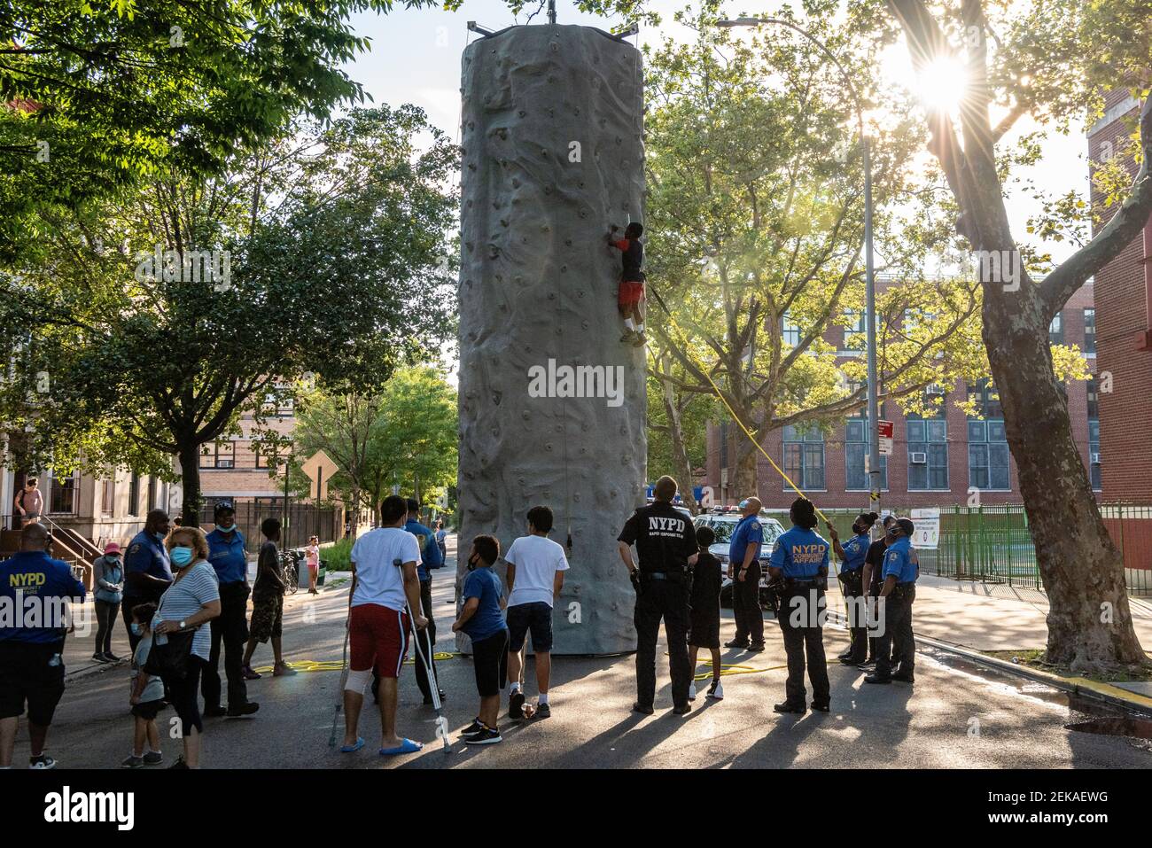 NYPD officers assist a young person conquer the rock climbing wall on ...