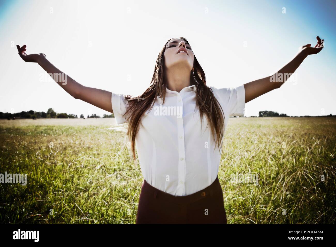 Teenage girl standing in a field with her arms outstretched Stock Photo ...