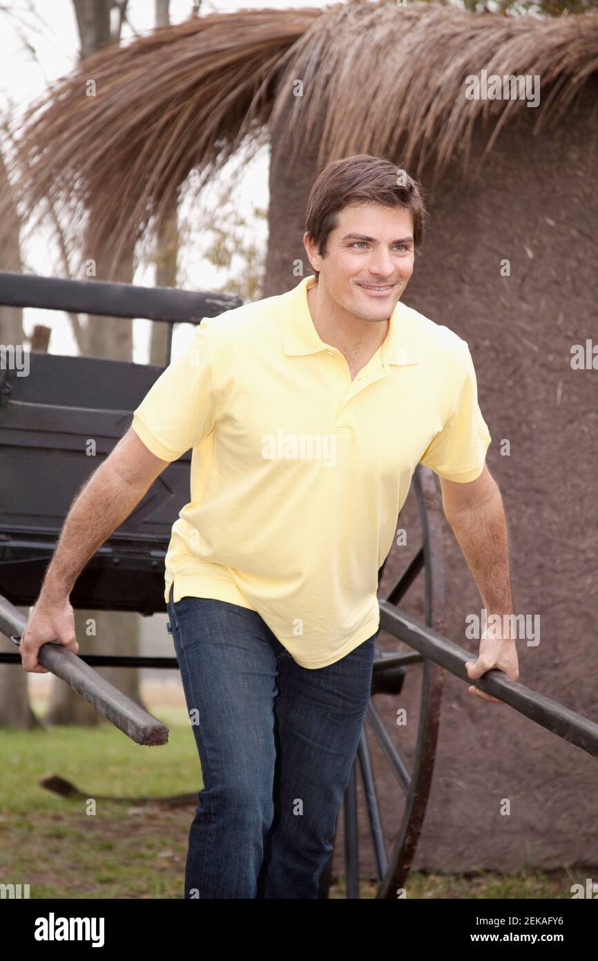 Man pulling a cart and smiling Stock Photo - Alamy