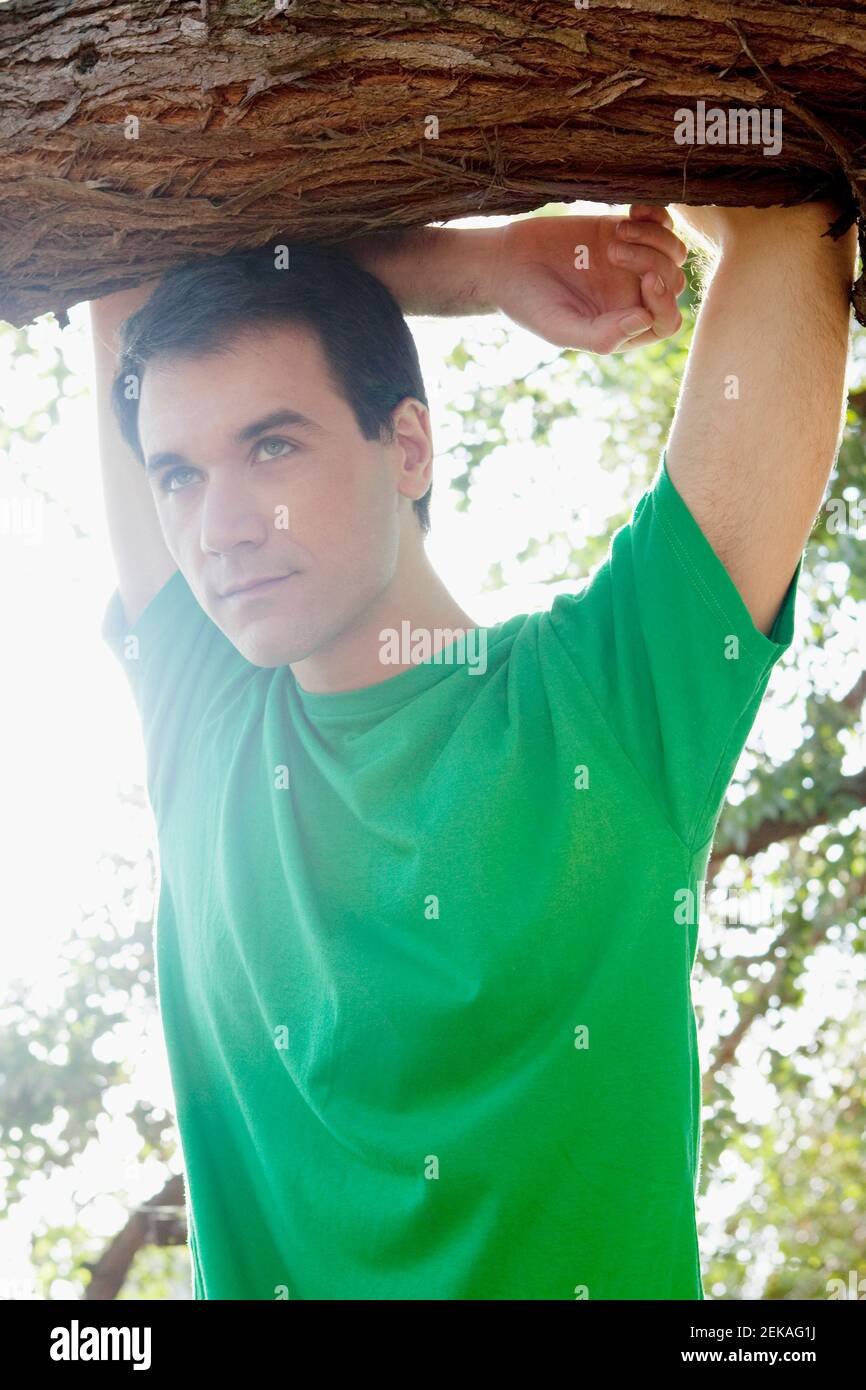 Man leaning on a tree branch Stock Photo - Alamy
