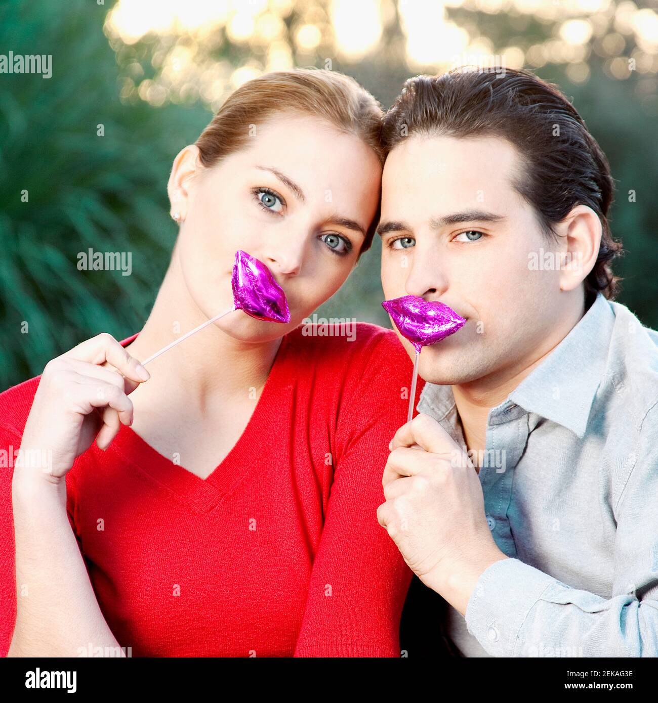 Couple holding lip shape toys in front of their lips Stock Photo - Alamy