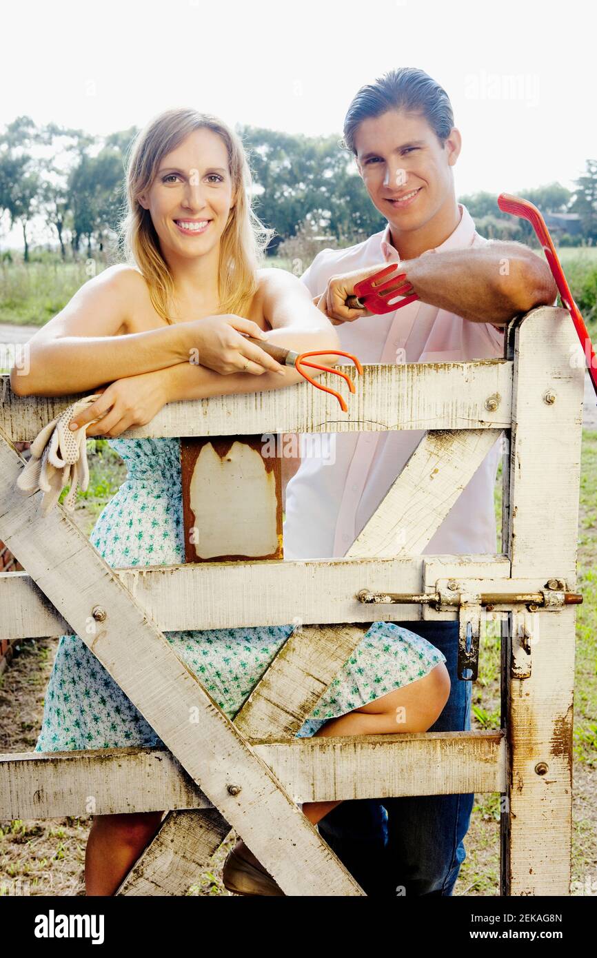 Couple leaning on the gate of a fence Stock Photo - Alamy