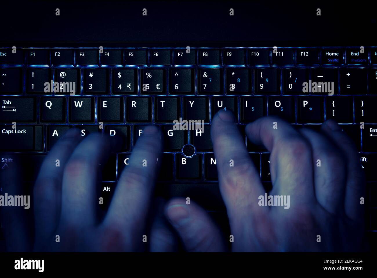 hands typing on keyboard in blue light with motion blur Stock Photo - Alamy
