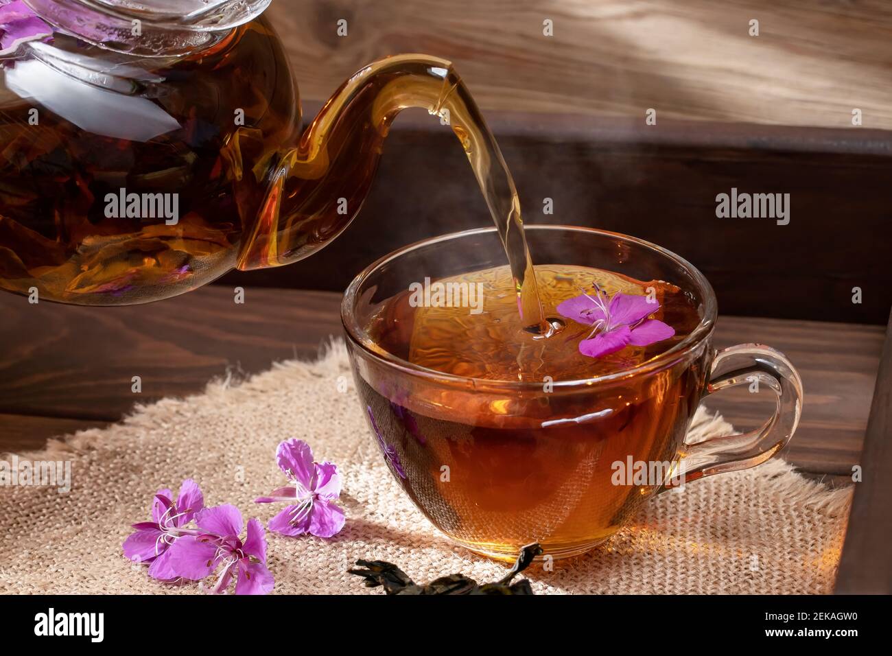 Pouring fireweed herbal tea into a transparent cup Stock Photo - Alamy