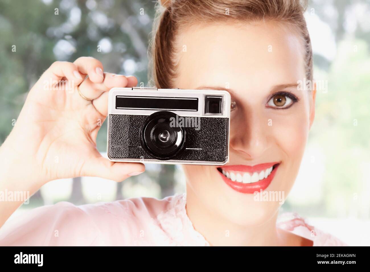 Woman taking a picture with a camera Stock Photo - Alamy
