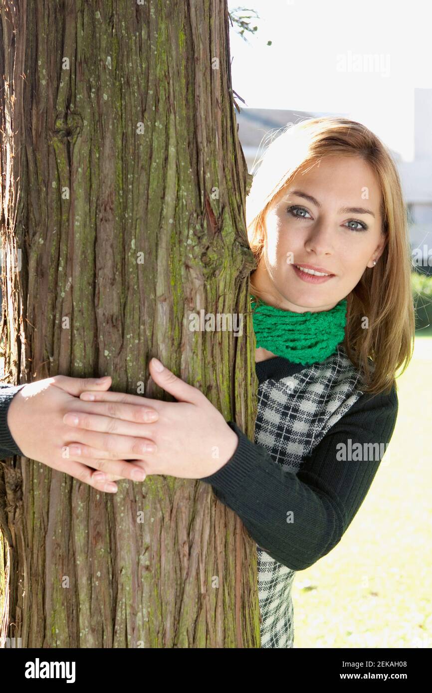 Portrait of a woman hugging tree Stock Photo - Alamy