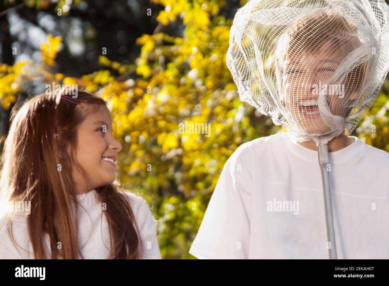 Girl looking at her brother wearing a fishing net on his head Stock ...