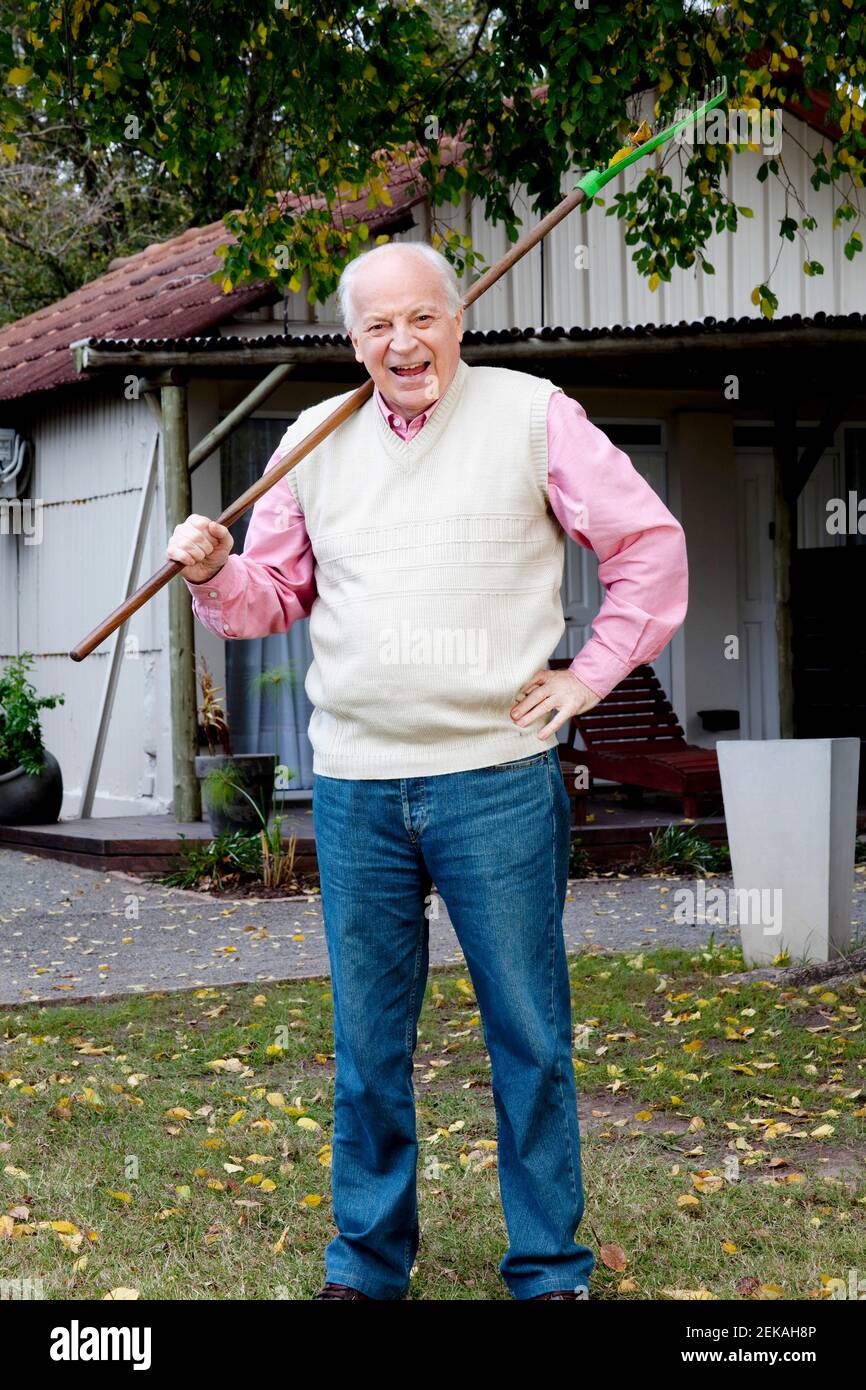Man holding rake in lawn hi-res stock photography and images - Alamy