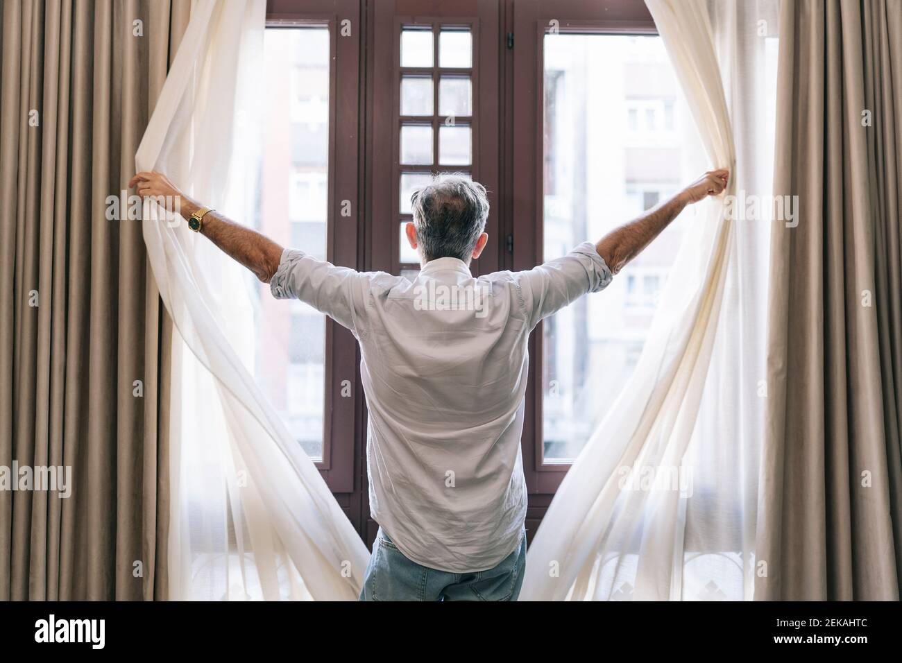 Man opening curtains hi-res stock photography and images - Alamy