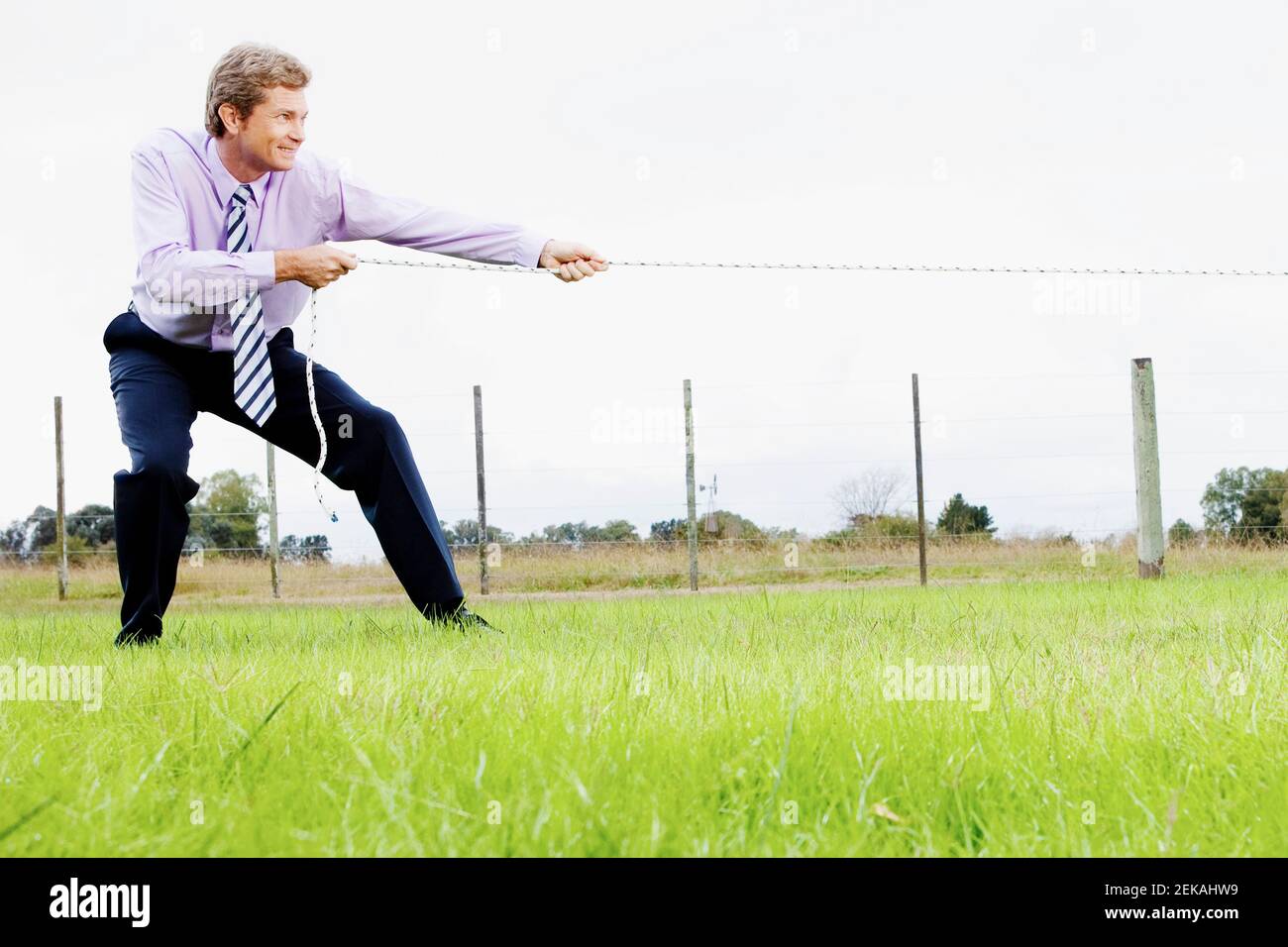 Businessman pulling a rope Stock Photo - Alamy