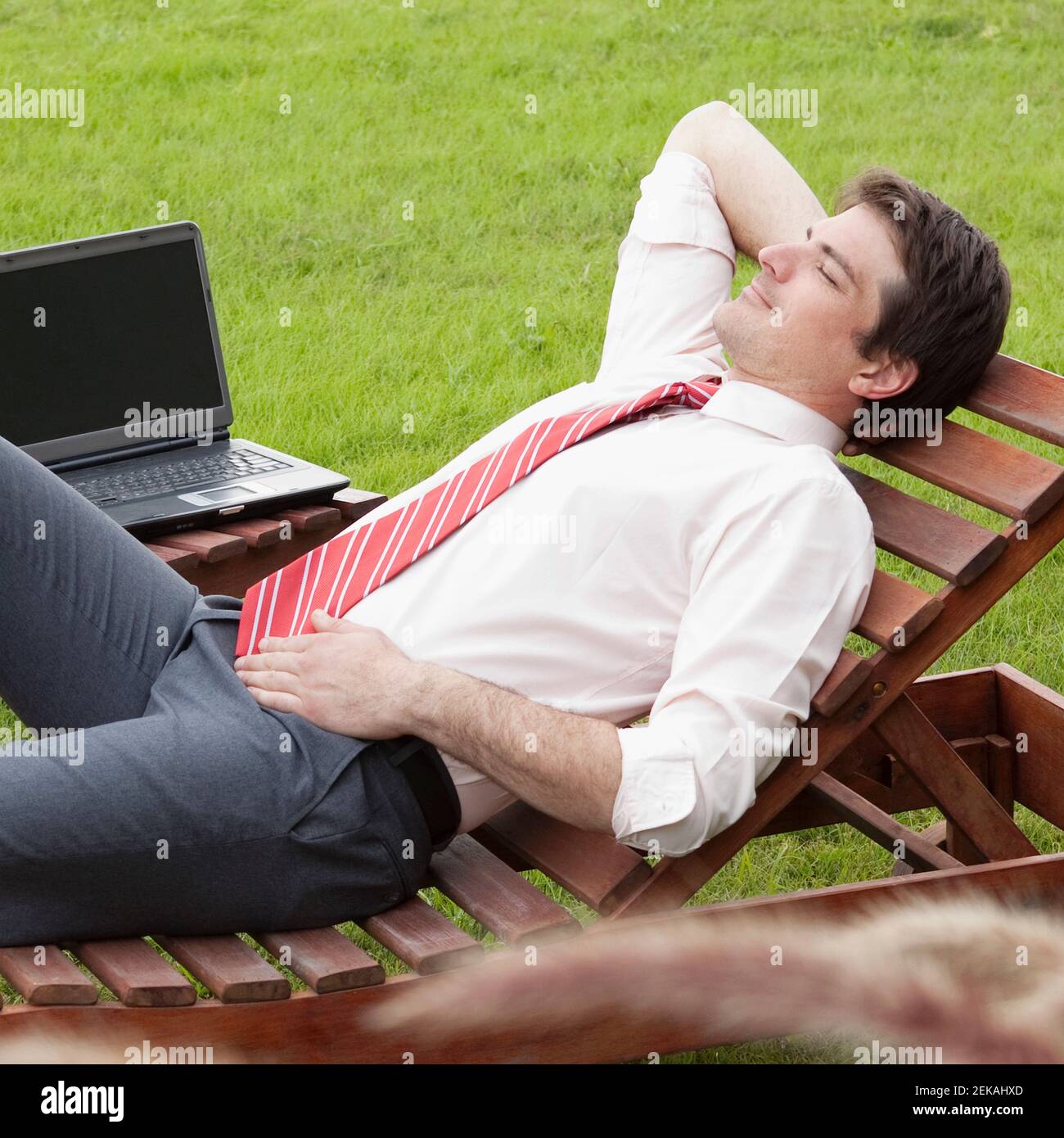 Businessman lying on a lounge chair Stock Photo - Alamy