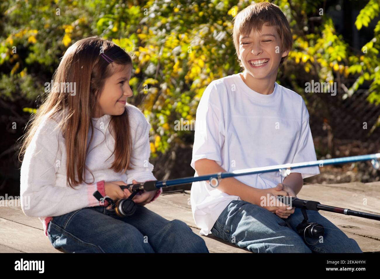 Girl fly fishing with her brother Stock Photo - Alamy