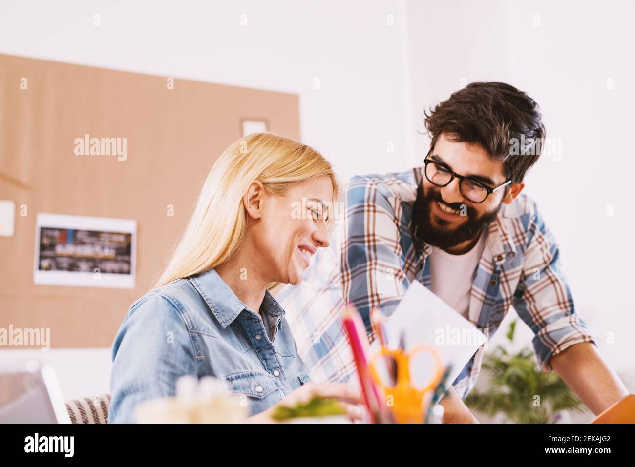 Happy young couple working together in the same office Stock Photo - Alamy