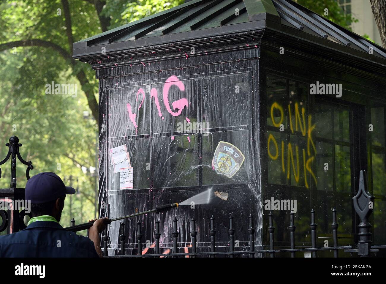 A New York City Department of Sanitation worker uses a pressure washer ...